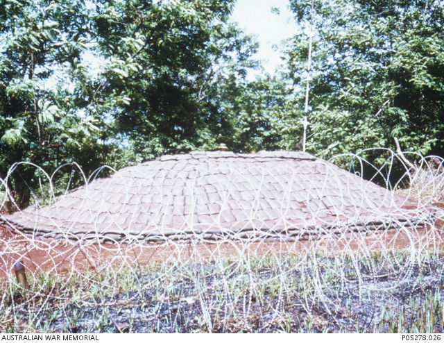 A dome shaped machine gun bunker behind a mass of barbed wire at Fire ...