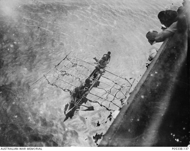 A small fishing boat pulls up alongside the German armed merchant ...