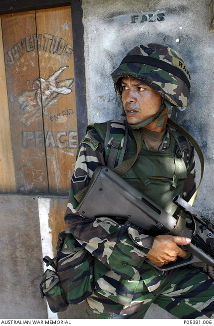 A Malaysian paratrooper, armed with a Steyr F88 assault rifle, patrols ...