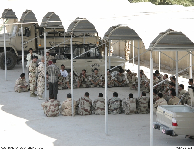 Members of the 603rd Battalion, Iraqi Army, seated in an covered area ...