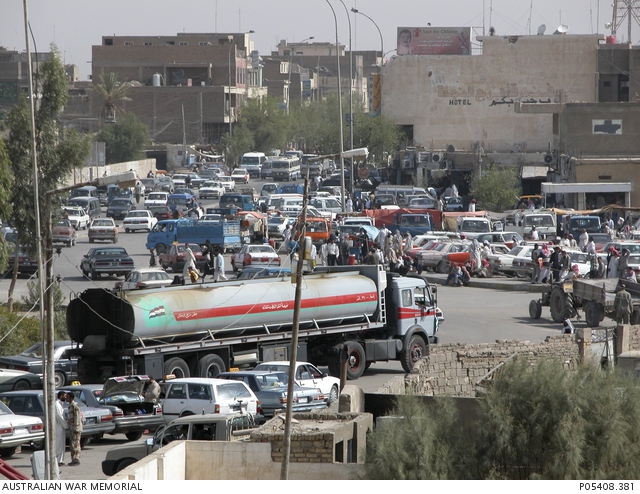 Trucks, cars and people line one of the main streets in As Samawah ...