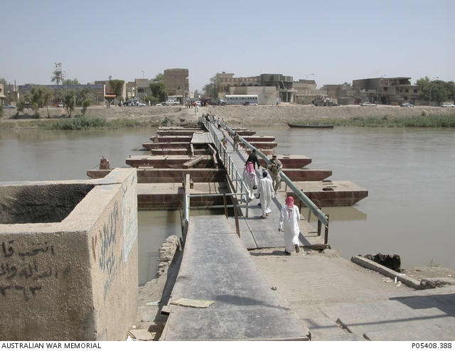 Australian soldiers and Iraqi locals crossing a foot bridge over the ...
