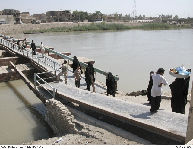 Australian soldiers and Iraqi locals crossing a foot bridge over the ...