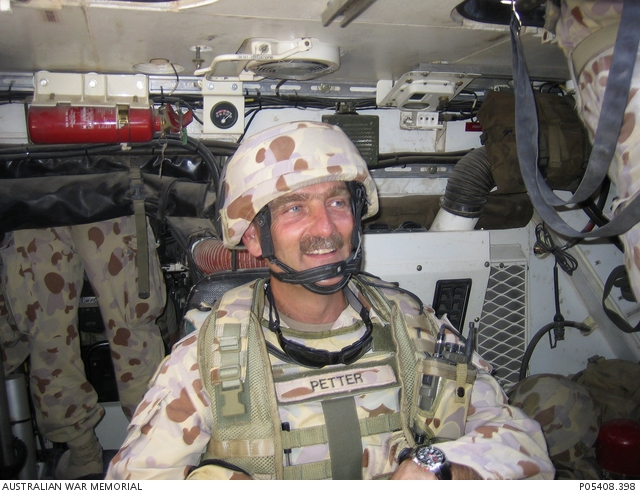 Informal portrait of Warrant Officer Class 2 (WO2) Paul Petter sitting ...