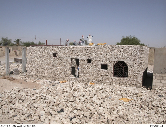 Iraqi building contractors standing on the roof of a partially ...