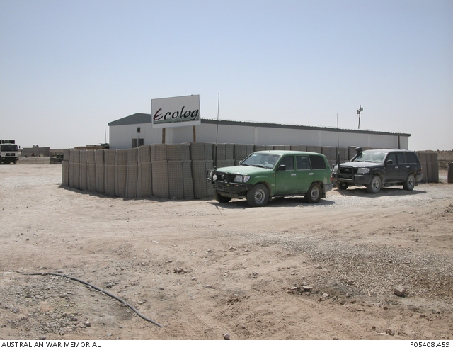 Two Land Rovers parked outside the laundry at Camp Smitty. There is a ...
