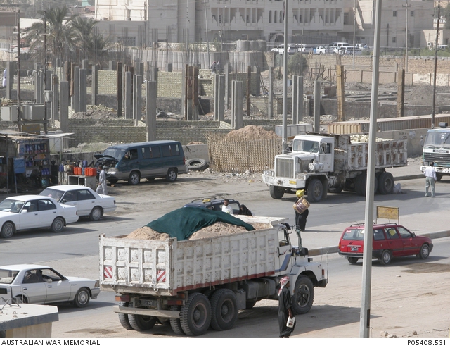 Cars and trucks driving past the new partially constructed education ...