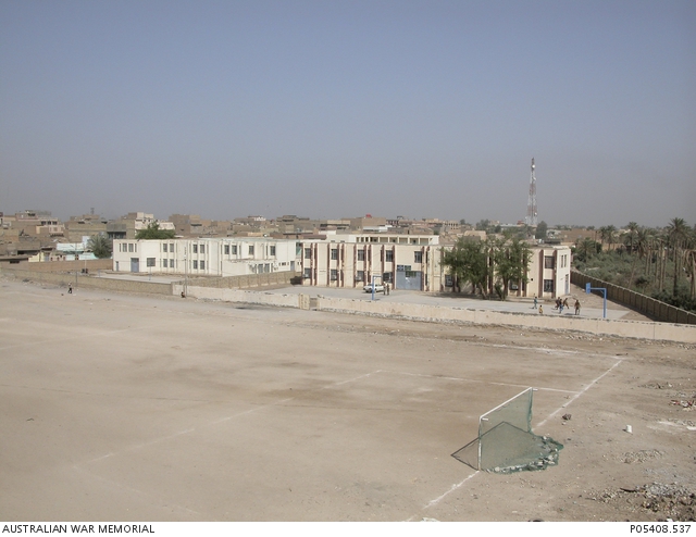An elevated view of a soccer field, without turf, and a basketball ...