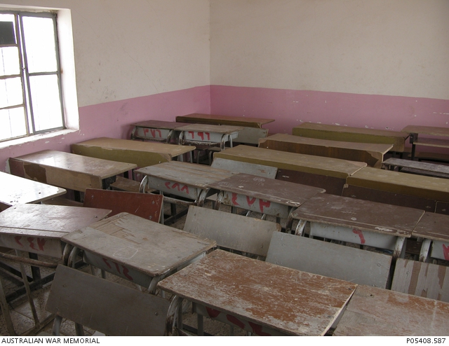 Old desks and chairs inside one of the class rooms in the school in the ...