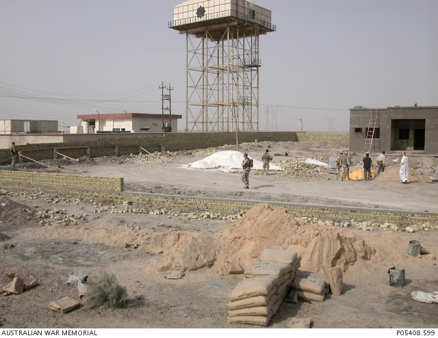 Members of the Civil Military Co-operation (CIMIC) Team, walk towards a ...