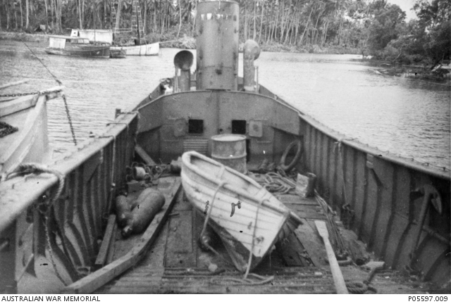 A Japanese barge with a smaller boat inside on the edge of the river at ...