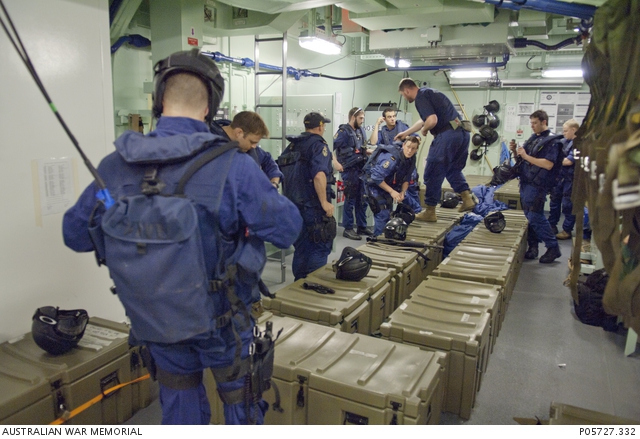 A boarding party 'kits up' and waits to receive instructions prior to ...