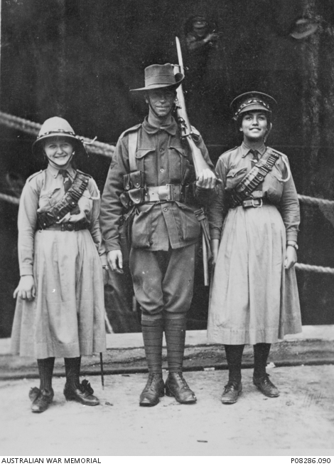 Two women in uniform beside an Australian soldier on guard. The ...