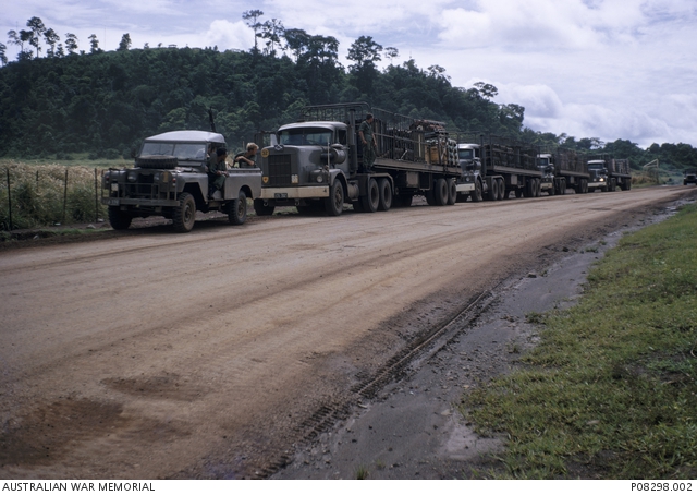 A convoy of vehicles consisting of a GS Land Rover and four Diamond Reo ...