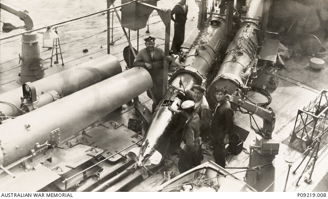 Royal Australian Naval personnel loading a torpedo into its firing tube ...