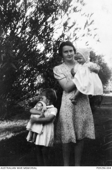 Informal portrait of Wendy Rudduck wearing bonnet and silk dress held ...