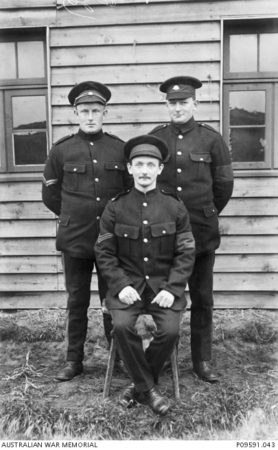 Outdoor group portrait of three unidentified Allied prisoners of war ...