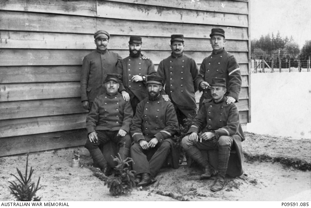 Outdoor group portrait of seven unidentified Allied prisoners of war ...