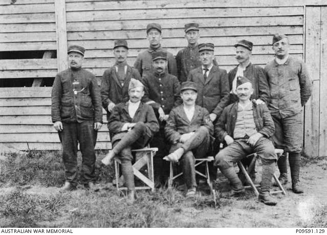 Outdoor group portrait of eleven unidentified allied prisoners of war ...