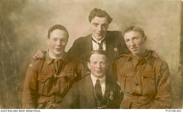 Studio portrait of two young soldiers in uniform and two men in ...