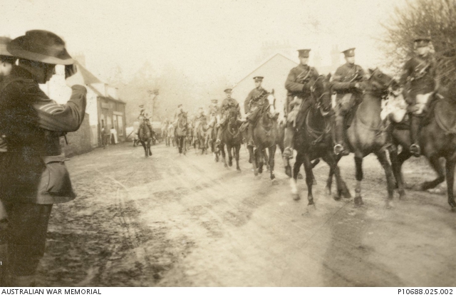 An unidentified Australian sergeant salutes as a troop of British ...