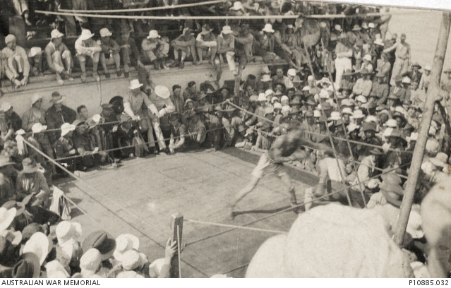 A crowd watches a boxing match upon the SS Persic as it sails troops ...