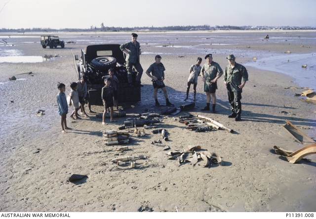 Members of CDT3 view enexploded ordnance laid out on a beach after it ...