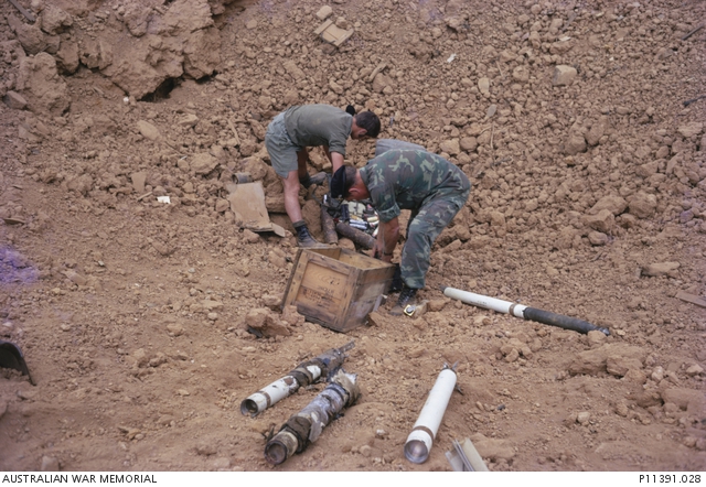 Two unidentified members of CDT3 prepare some 2.75 inch rockets and ...