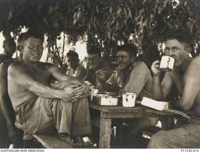 Australian soldiers eat in the camouflaged mess hut. Identified ...