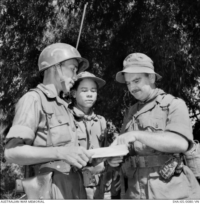 Vietnam. 1965. Warrant Officer 2 McGrellis gives a final map check to ...