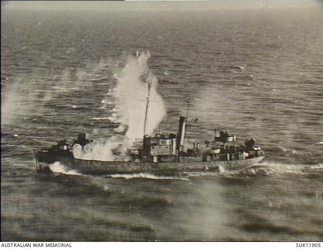 At sea off the Dutch coast. C. 1944. A heavily armed trawler ablaze in ...