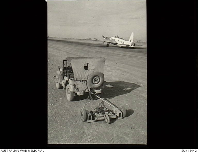 Italy. C. 1944-11. The magnetic sweep hooked to the back of a jeep, on ...