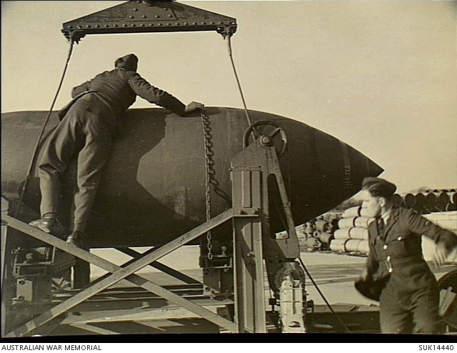 England. C. 1945-03. A ten-tonner 22,000 lb bomb is gently lowered into ...
