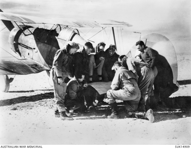 SALUM, EGYPT. C. 1941-01. NO. 3 SQUADRON RAAF PILOTS EXAMINE A MAP ON ...