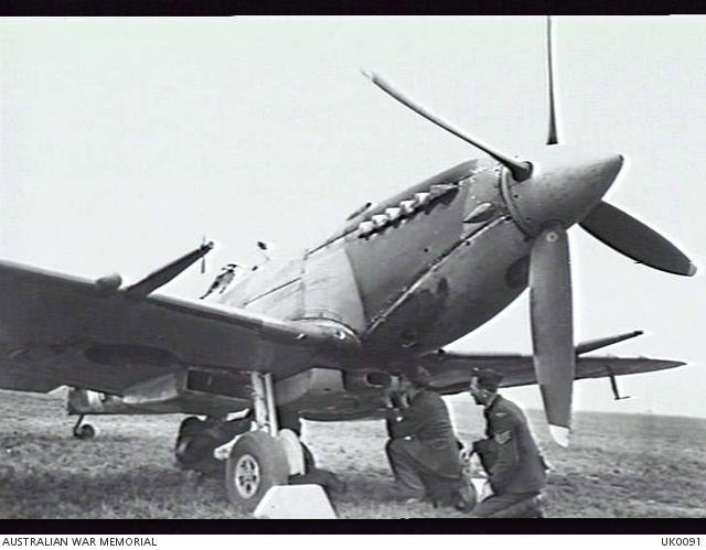 LONDON, ENGLAND. 1943-04-21. FITTING A SPARE PETROL TANK TO A SPITFIRE ...