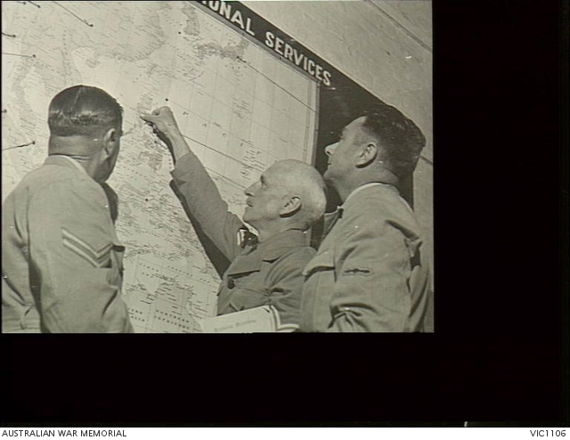 West Melbourne, Vic. Three RAAF personnel study a map of the ...