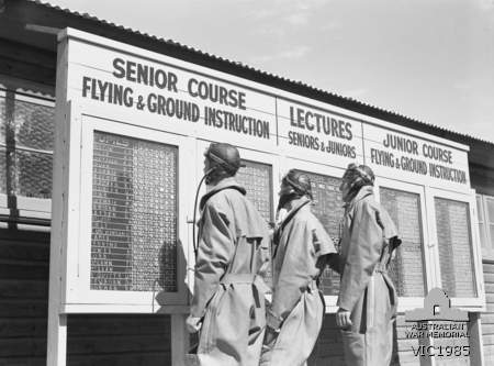 Three trainee pilots checking the programme board at No. 5 Elementary ...