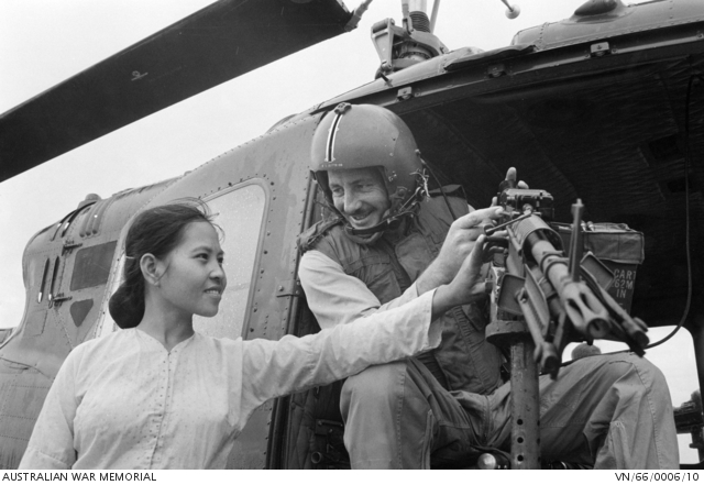 A local Vietnamese woman finds interest in the M-60 helicopter machine ...