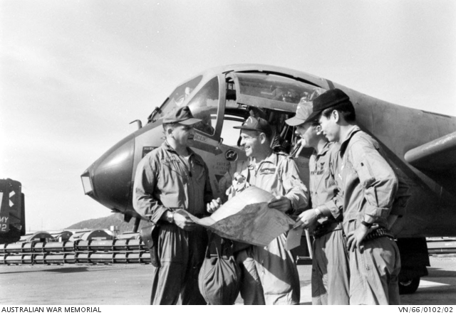 Four service personnel stand near the nose of a gunman United States ...