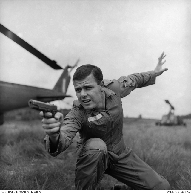 Pilot Officer (Plt Off) John Byrnes poses with his 9mm pistol ...