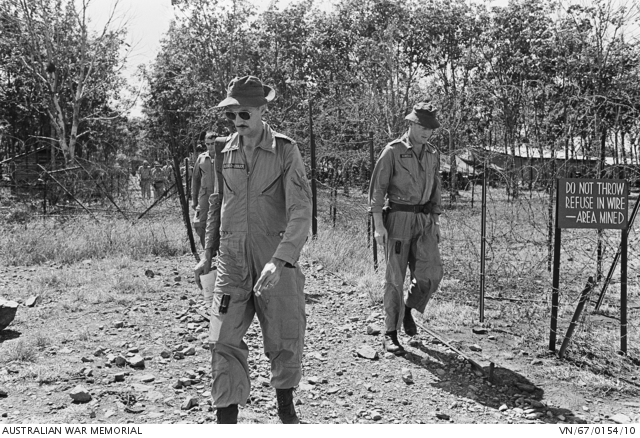 No 9 Squadron RAAF aircrew walk through barbed wire defences to their ...