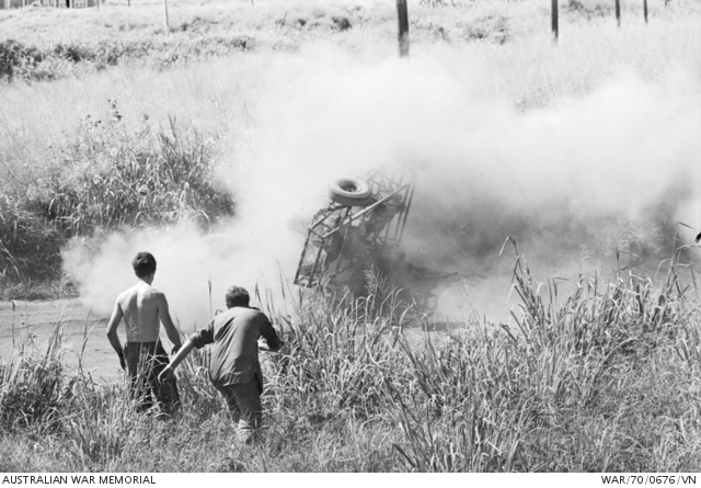 Nui Dat, South Vietnam. August 1970. Two soldiers run to help a mate as ...
